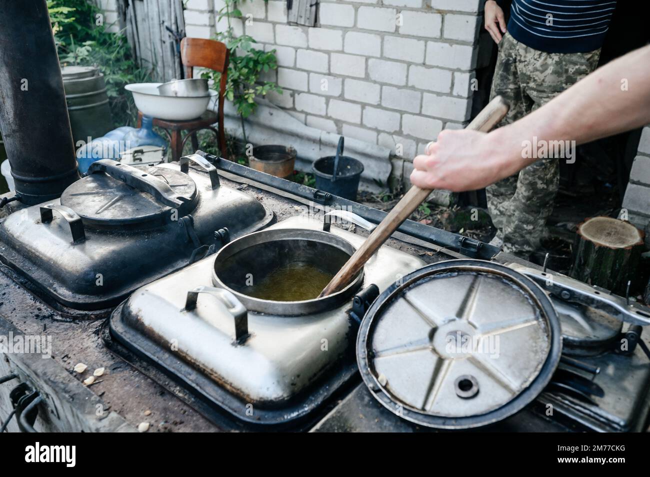 A man prepares lunch in a military field kitchen, a large wooden ...