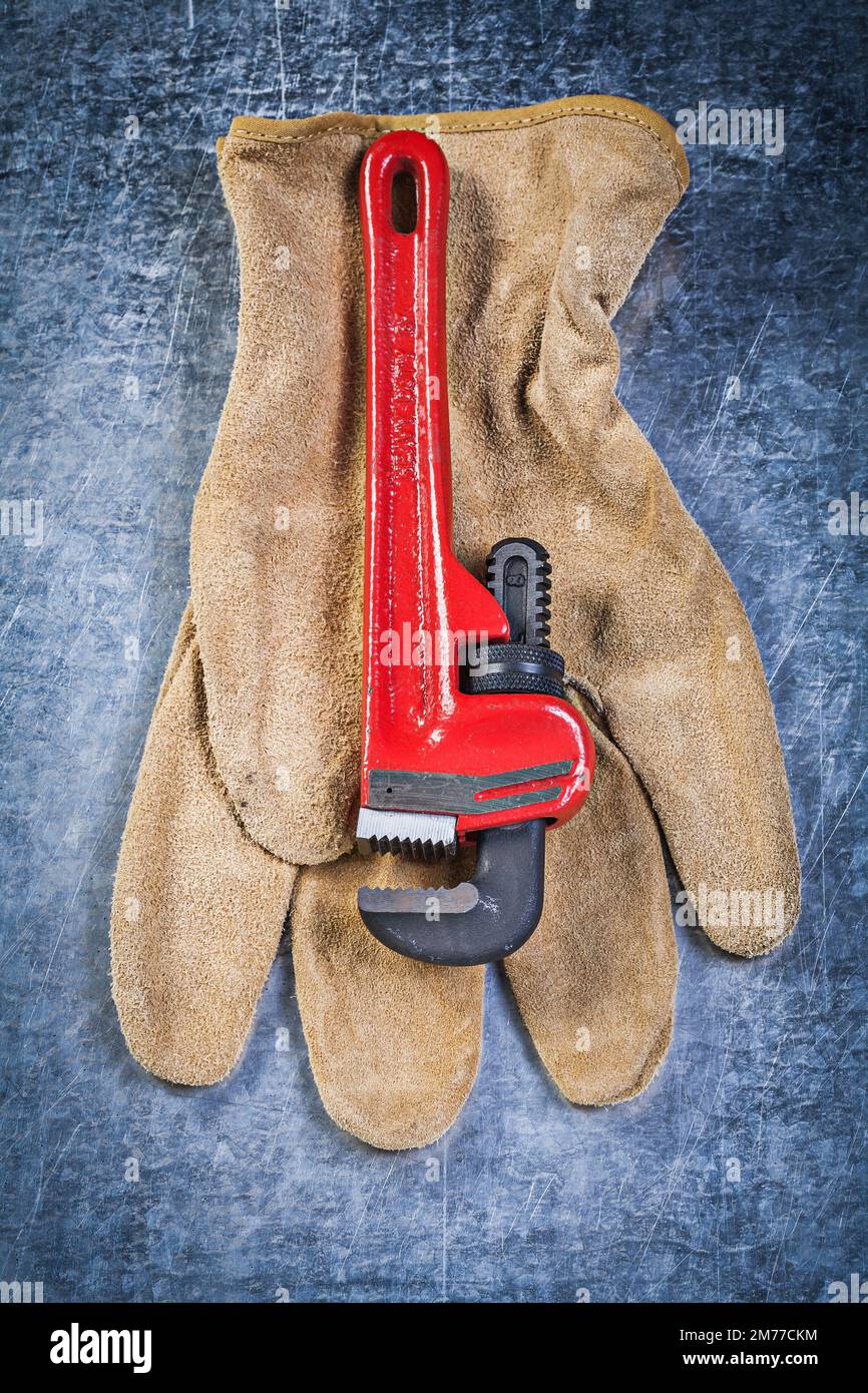 Pipe wrench safety gloves on metallic background construction concept ...