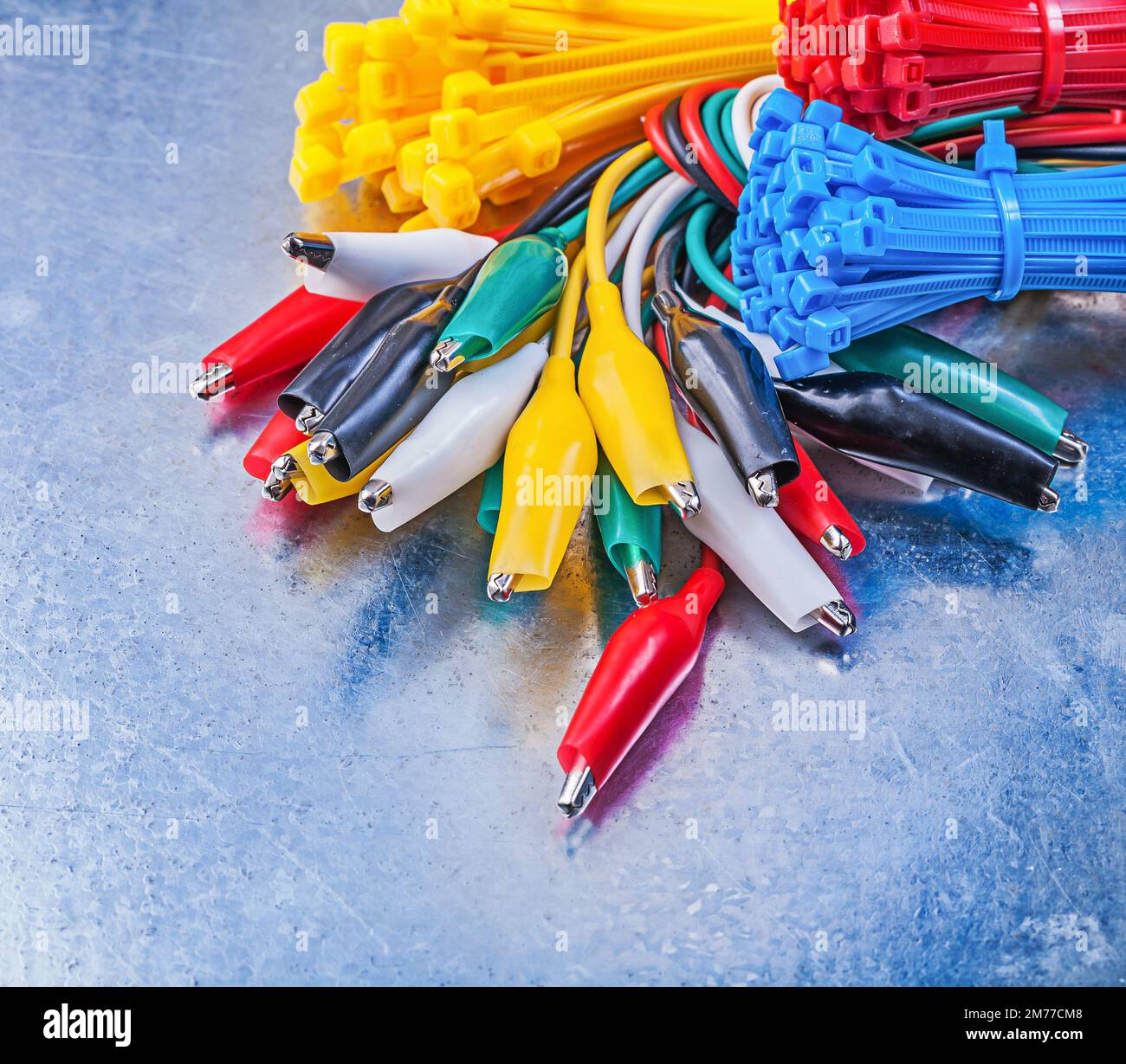 Plastic tying cables electric crocodile plugs on scratched metallic ...