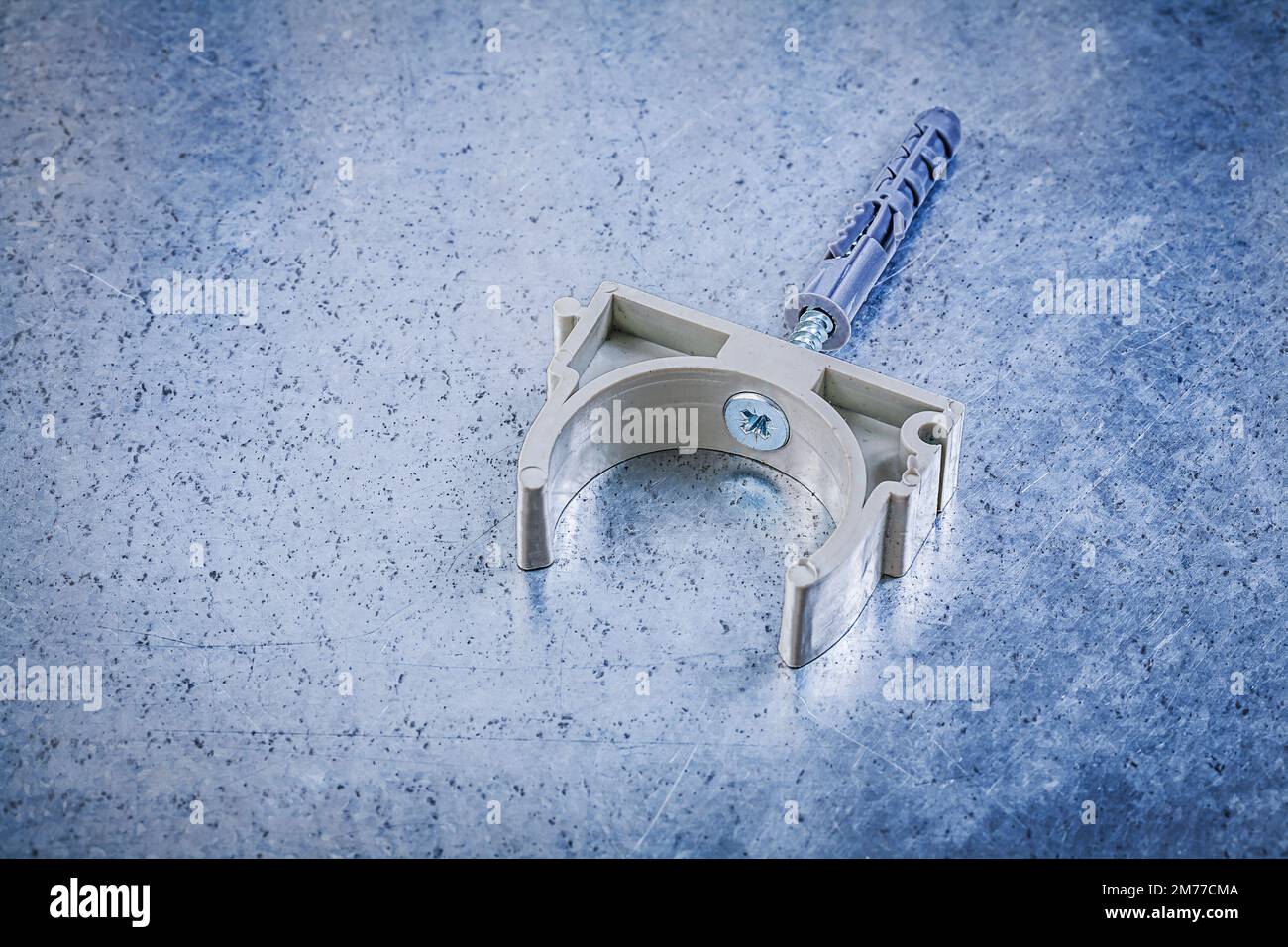 Plastic pipe clamp on metallic background top view construction concept ...