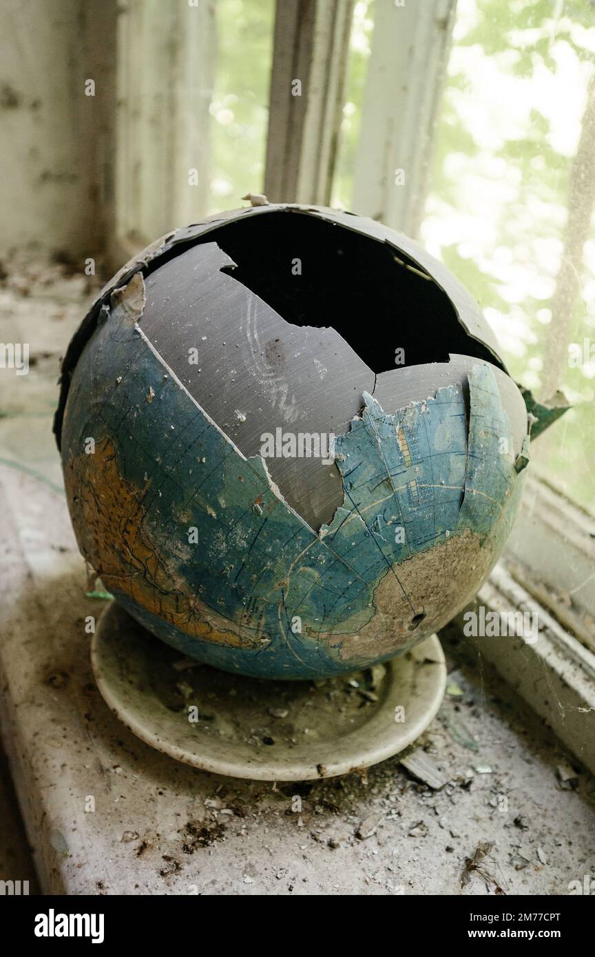 A broken globe on a window in an abandoned and destroyed school, Earth ...