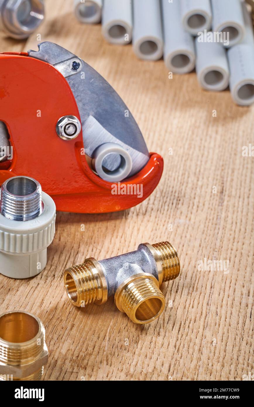 plumbing fixtures and pipe cutter with pipes on wooden board Stock ...