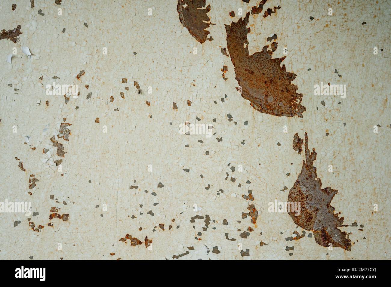 rusty wall with white paint, piece of painted metal with protruding ...