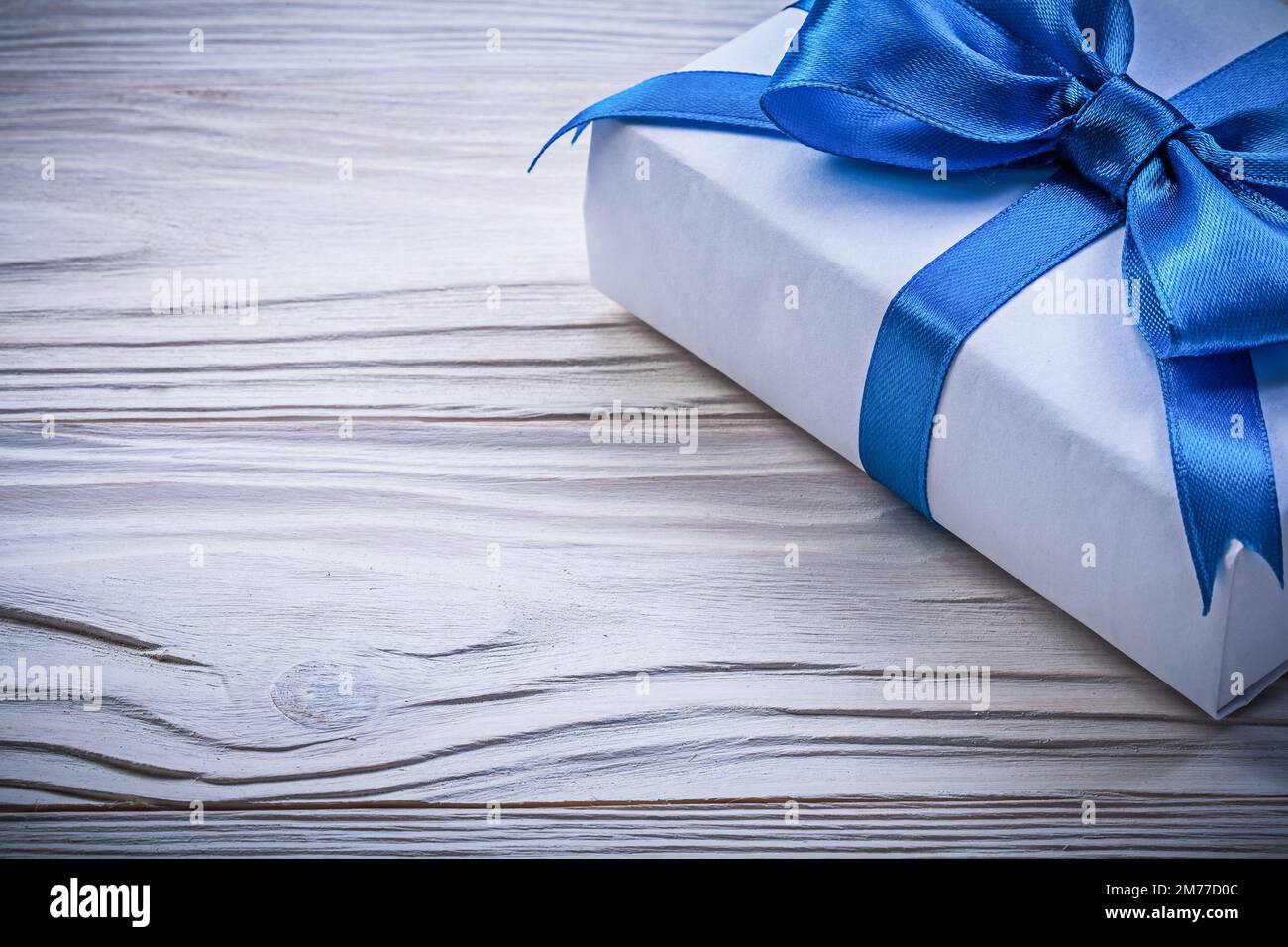 Present box with blue satin tape on wooden board celebrations concept ...