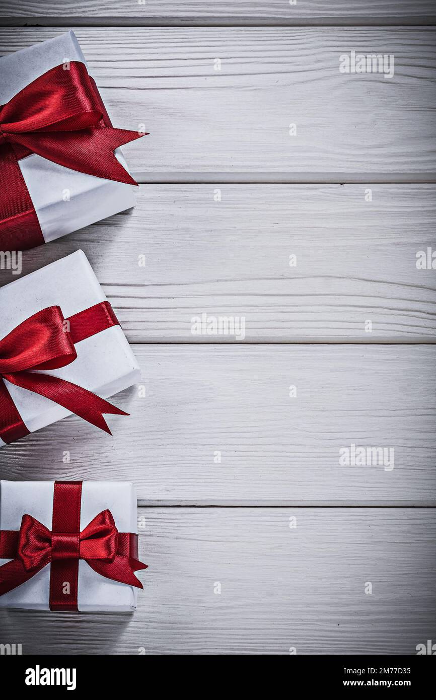 Present boxes with red bows on wooden board holidays concept Stock ...