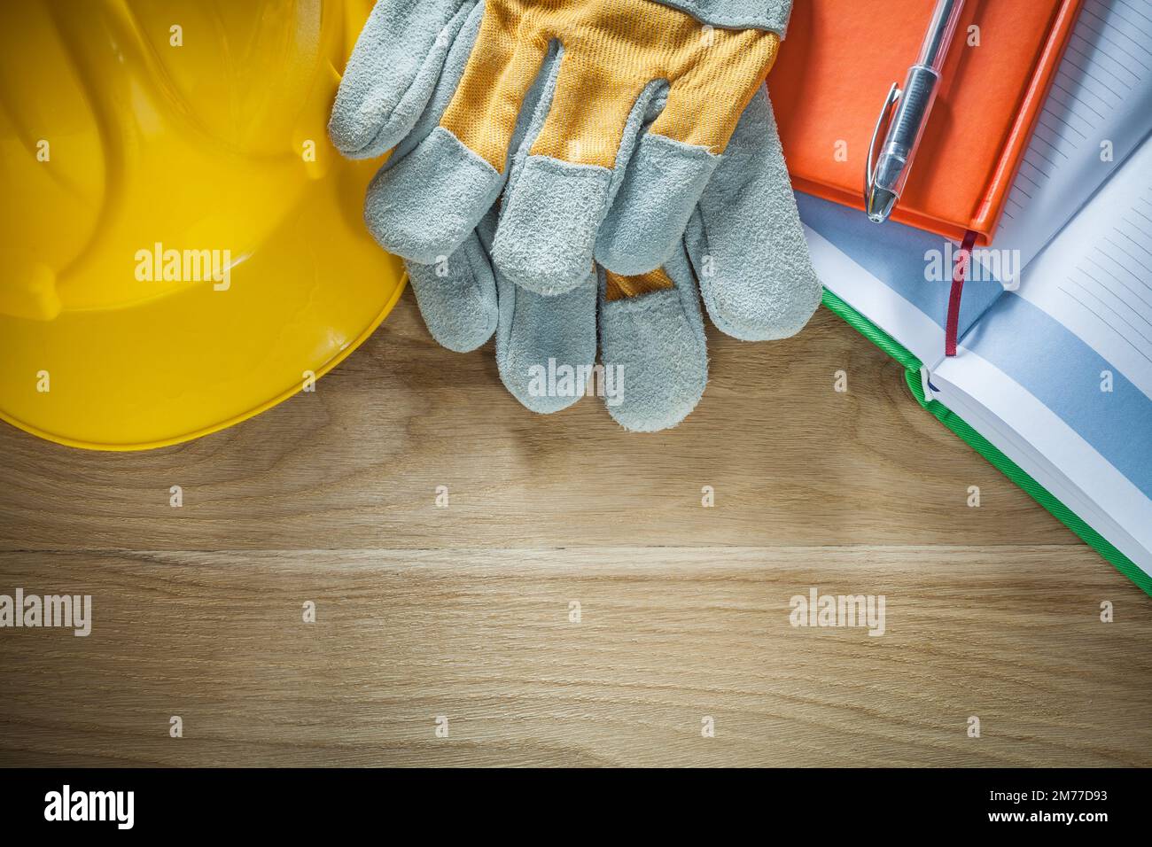 Protective gloves notepads pen hard hat on wooden board Stock Photo - Alamy