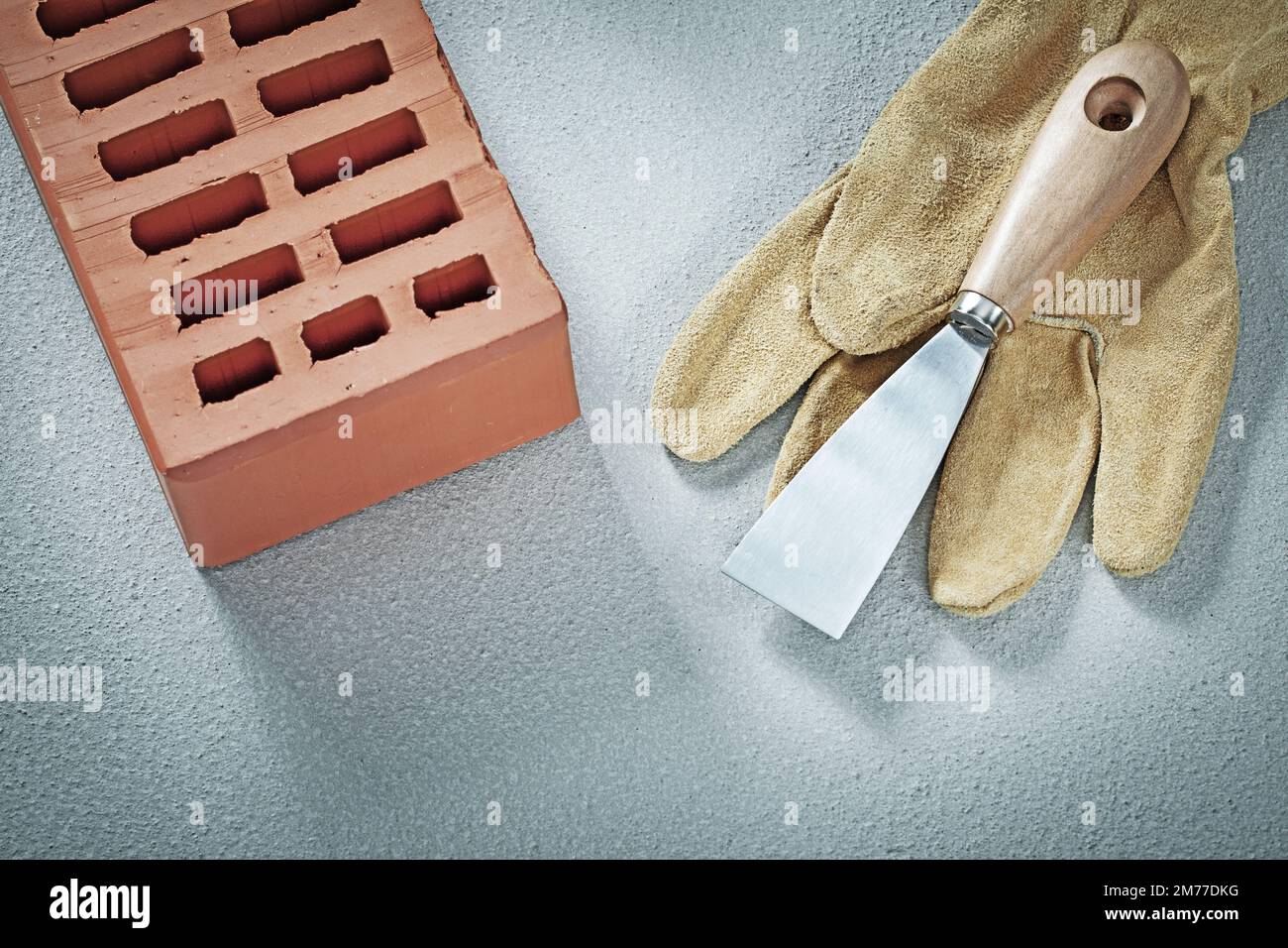 Red bricks protective gloves plastering trowel on concrete background ...