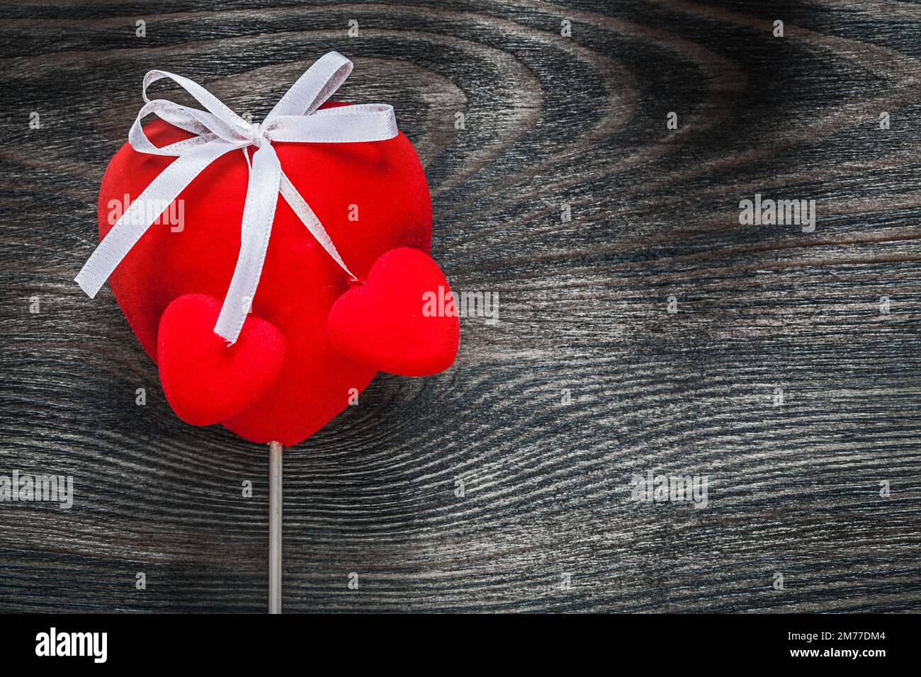 Red fabric hearts with white ribbons on wooden board holidays concept ...