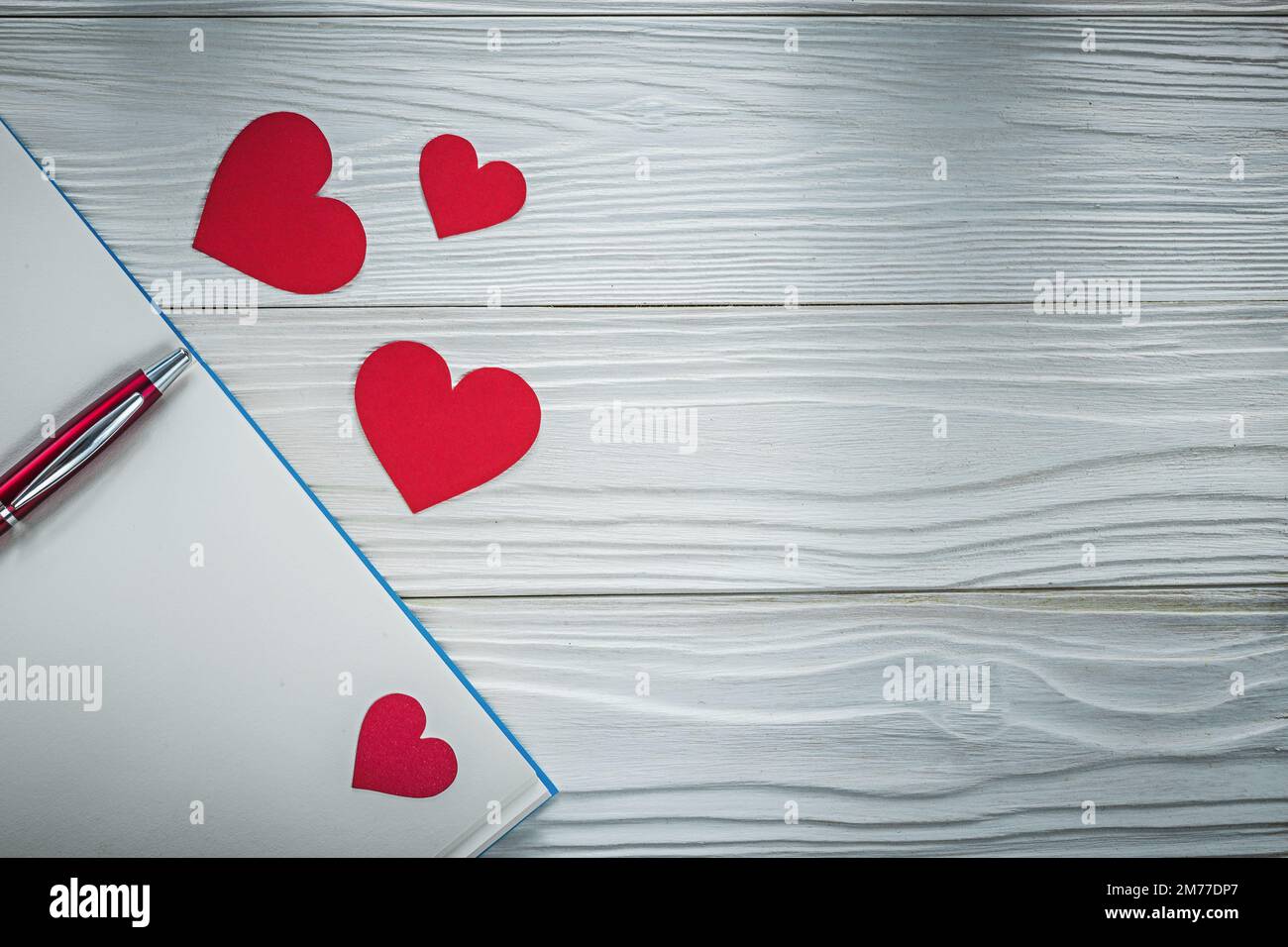 Red hearts ball-point pen clean notepad on wooden board education ...