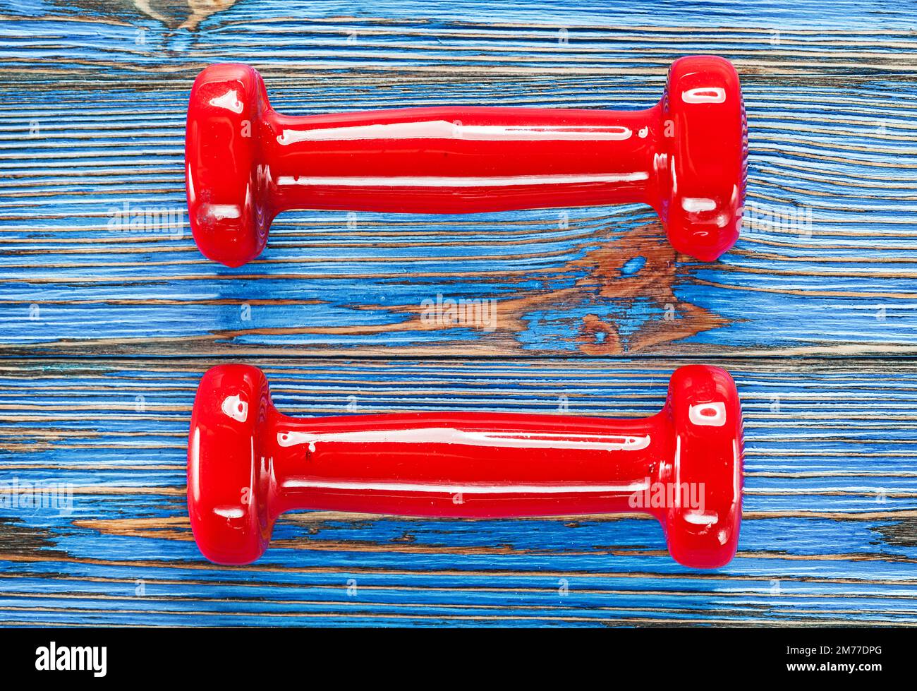 Red fitness dumbbells on vintage wooden board Stock Photo - Alamy