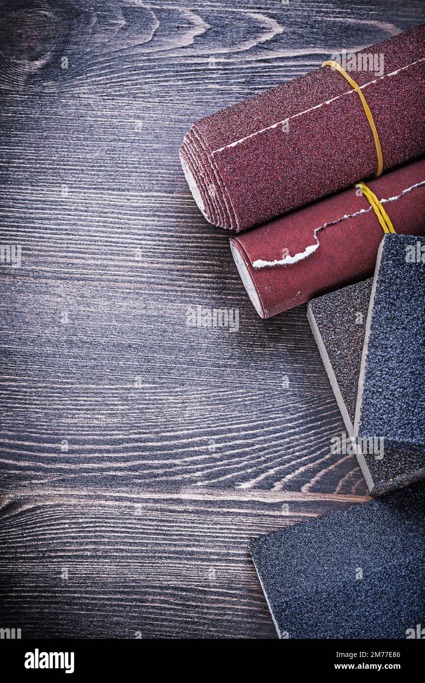 Rough abrasive paper sponges on vintage wood board construction concept ...