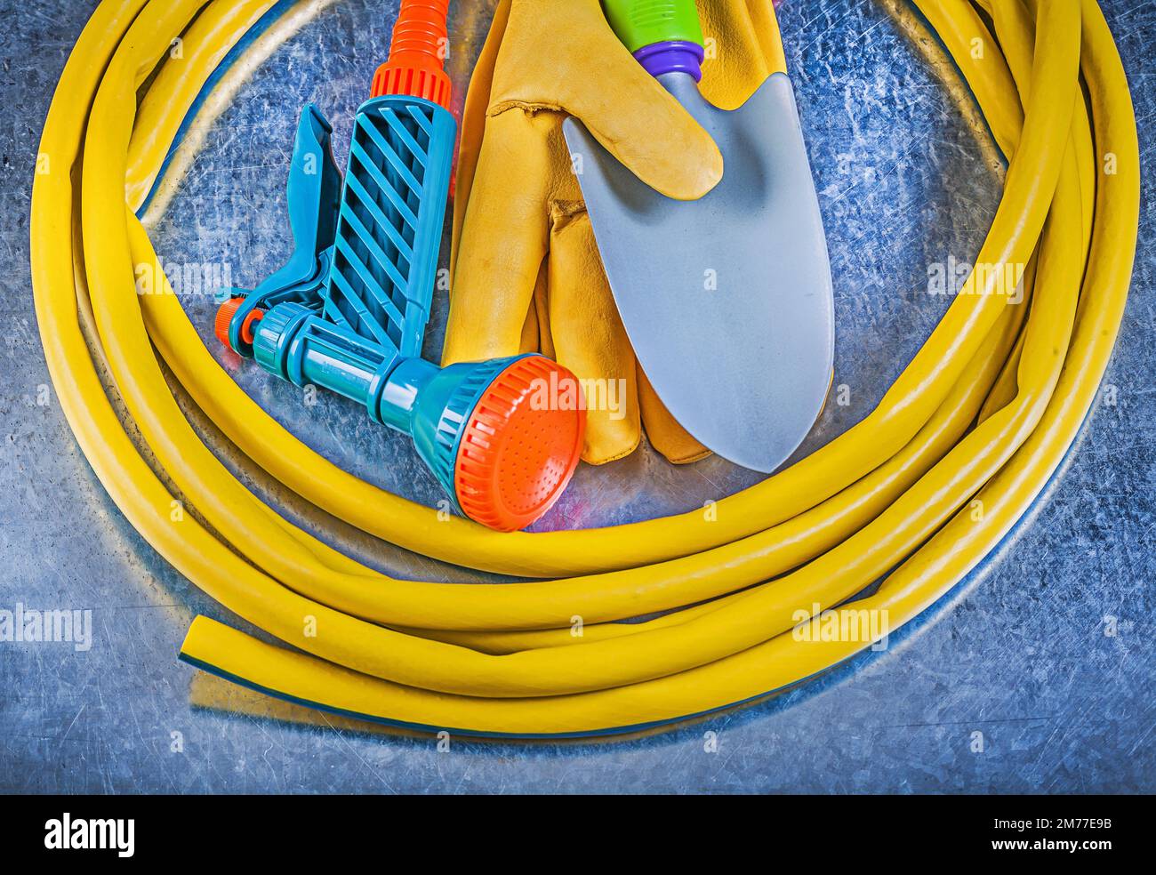 Rubber hand spraying garden hose protective gloves spade on metallic ...