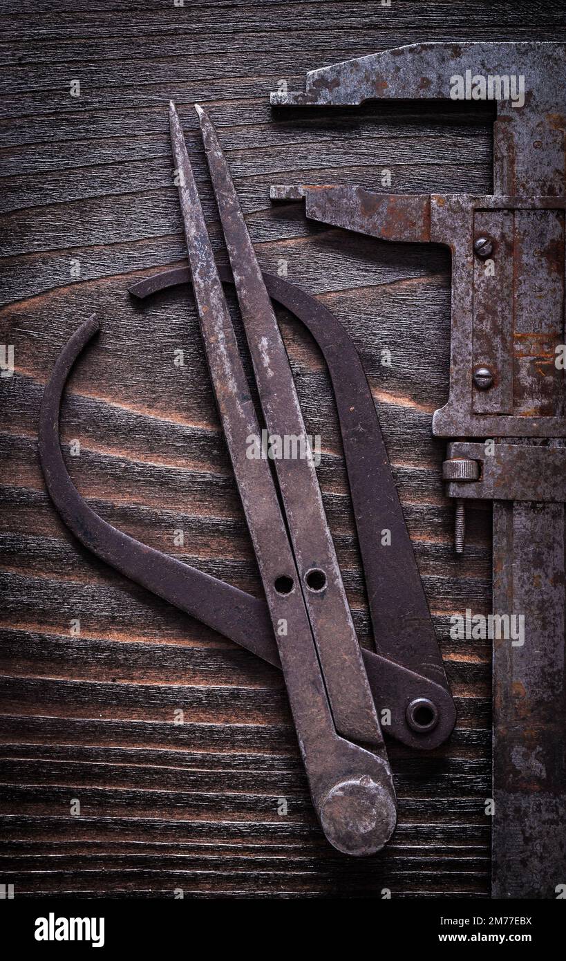 Rusty retro-styled measuring calipers on vintage dark wooden background ...