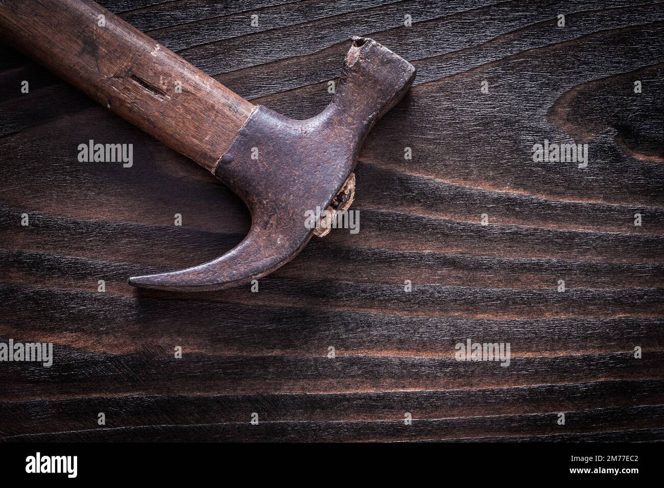 Rusty metal claw hammer on vintage dark wooden board top view ...
