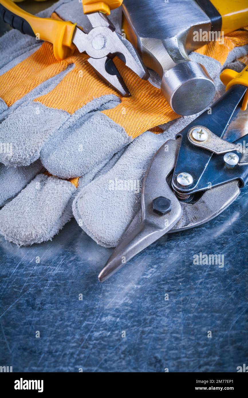 Safety gloves with claw hammer pliers and tin snips on scratched ...