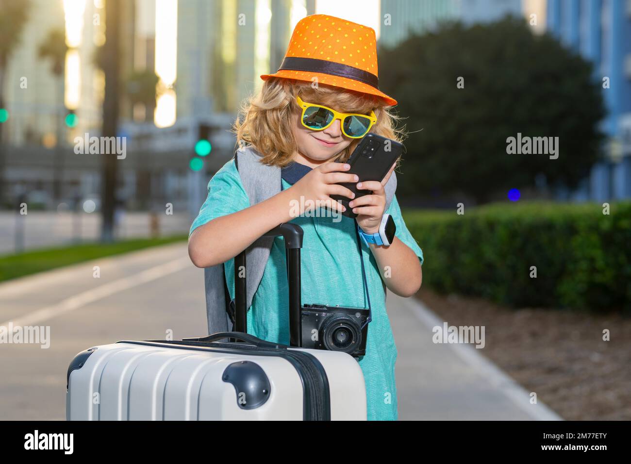 Portrait of happy child traveler with luggage. Positive little tourist ...