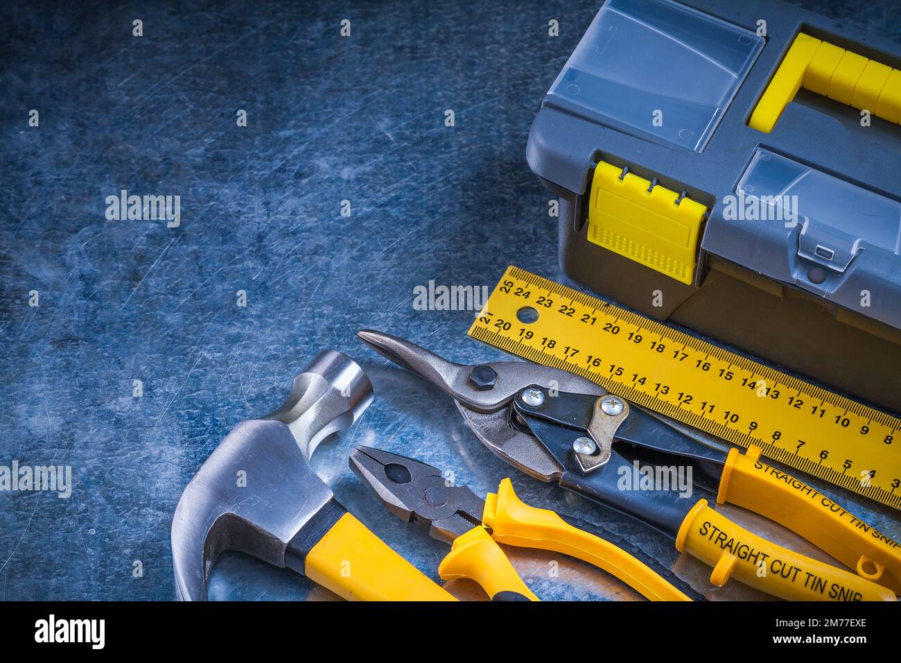 Scratched metallic background with toolbox hammer ruler pliers and tin ...