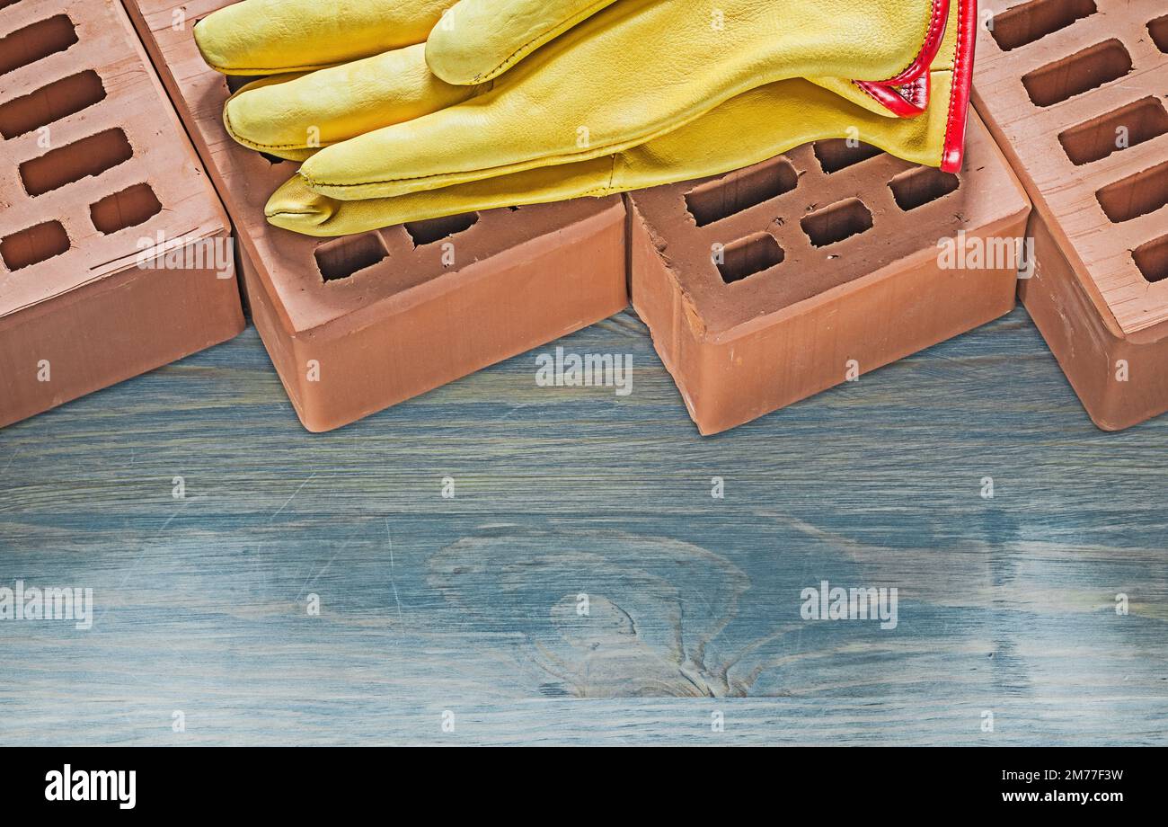 Set of building bricks protective gloves on wooden board construction ...