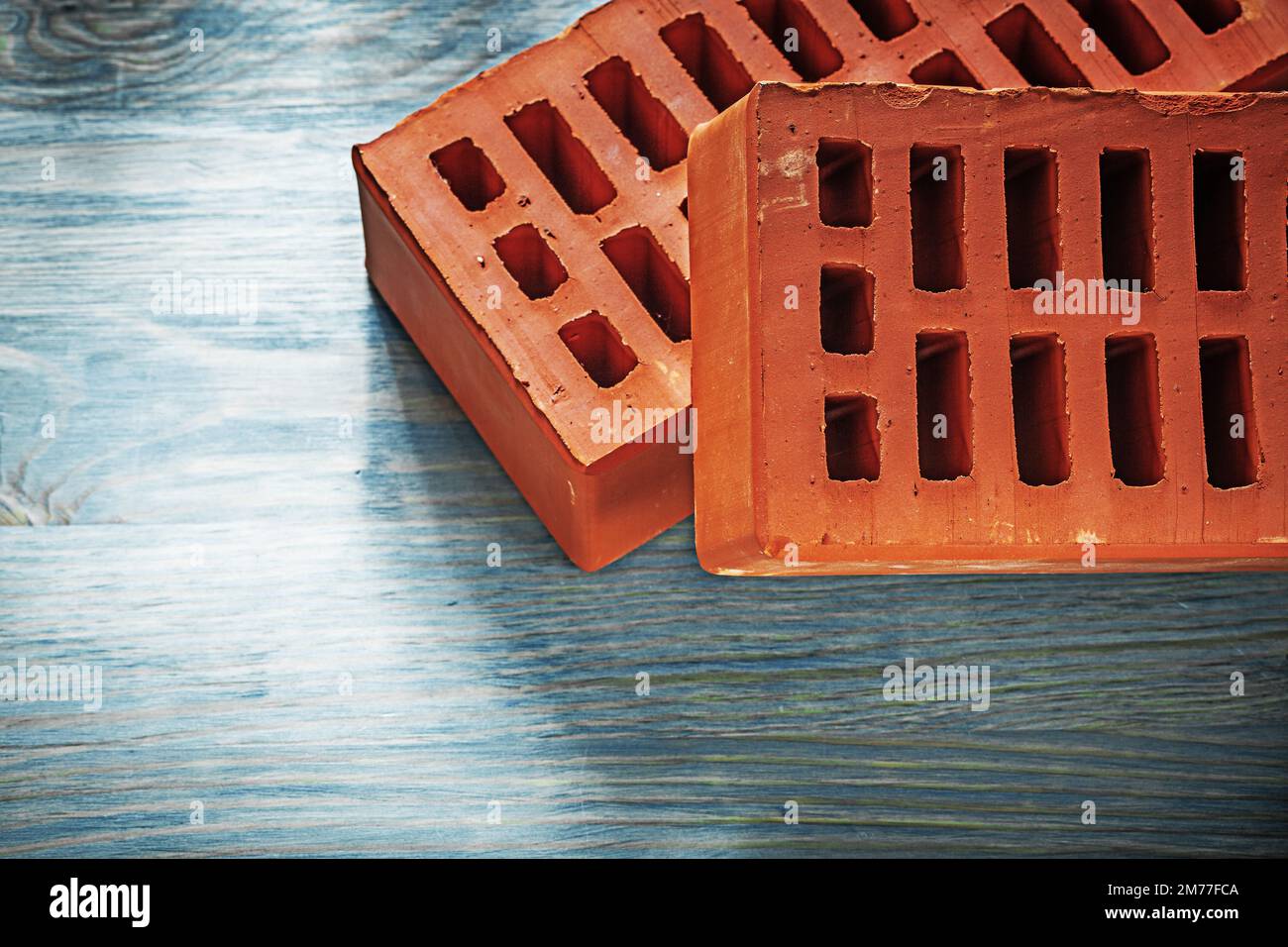 Set of red bricks on wood board construction concept Stock Photo - Alamy
