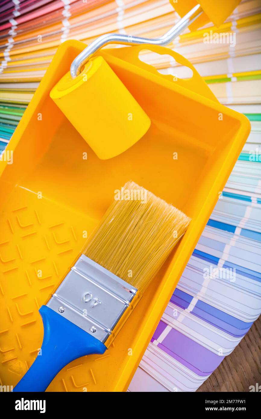 single paint brush in tray with roller on color palette construction ...