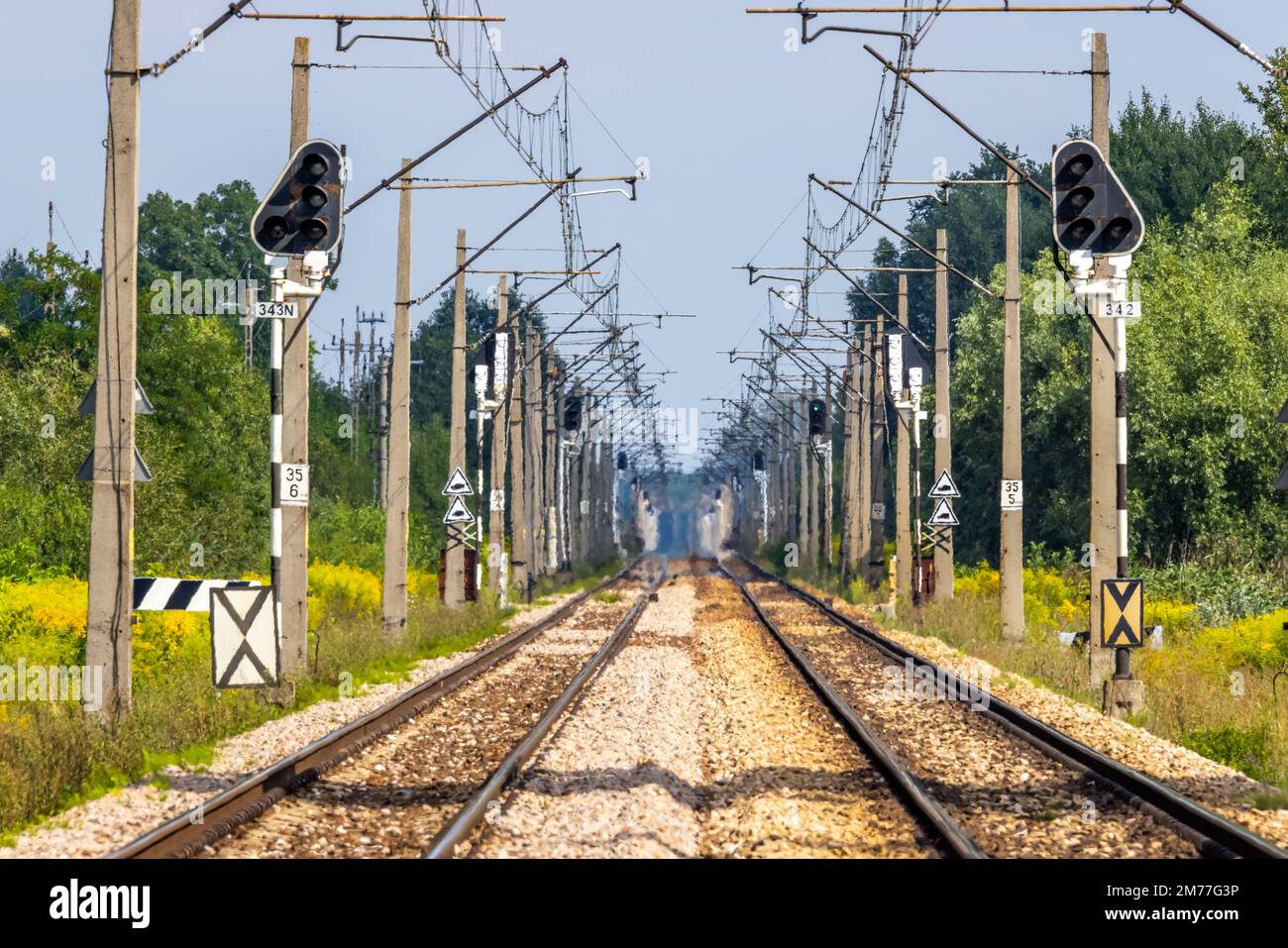Tracks of an electric railway line on a hot summer day. Perspective shot from human eye level ...