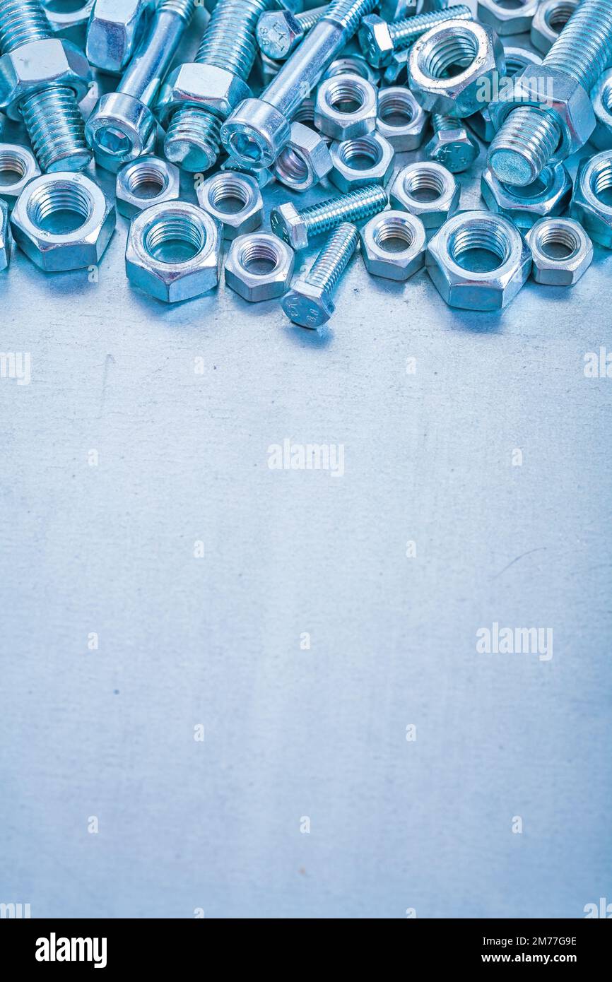 Stack of metal bolt details and screw nuts on metallic background ...