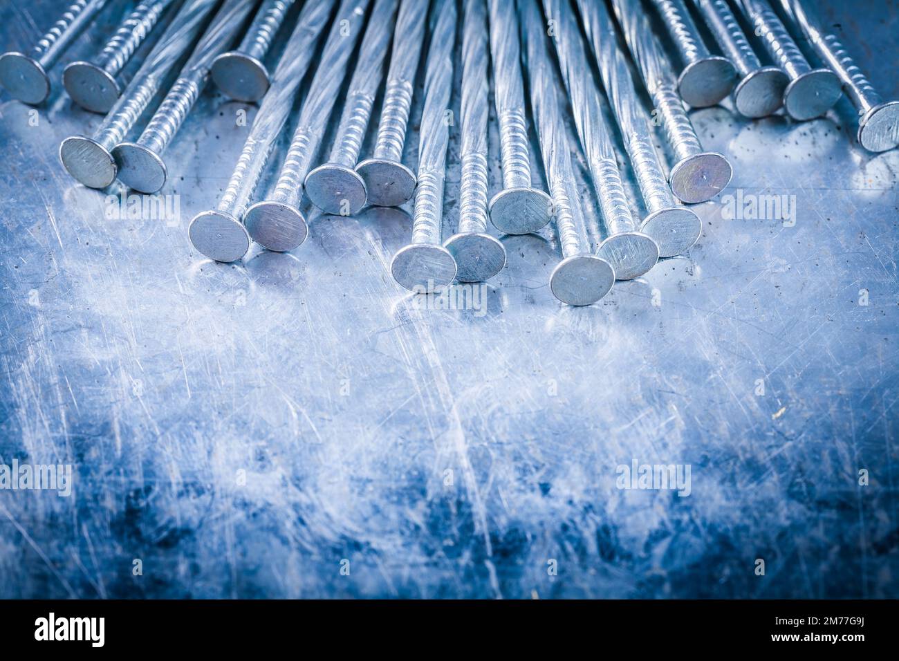 Stack of metal construction nails on scratched metallic surface ...