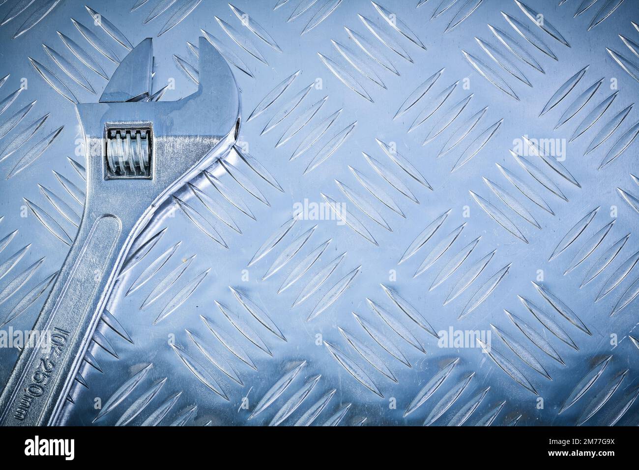 Stainless adjustable key on grooved metal plate construction concept ...