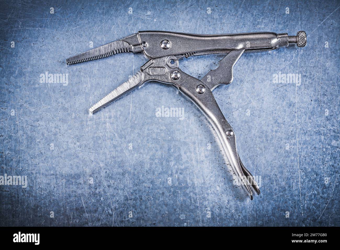 Stainless locking pliers with open jaws on metallic background Stock ...