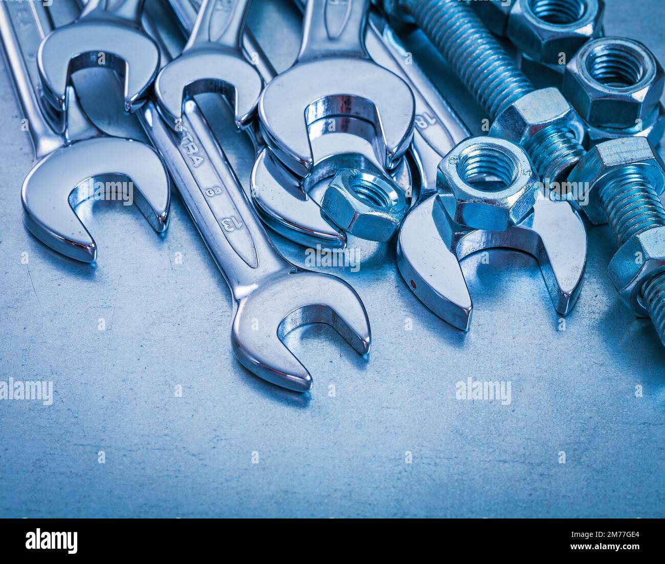 Stainless spanner wrenches bolts and screw nuts on metallic background ...