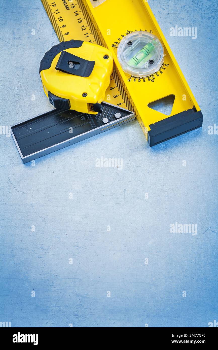 Tape measure construction level and square ruler on metallic background ...