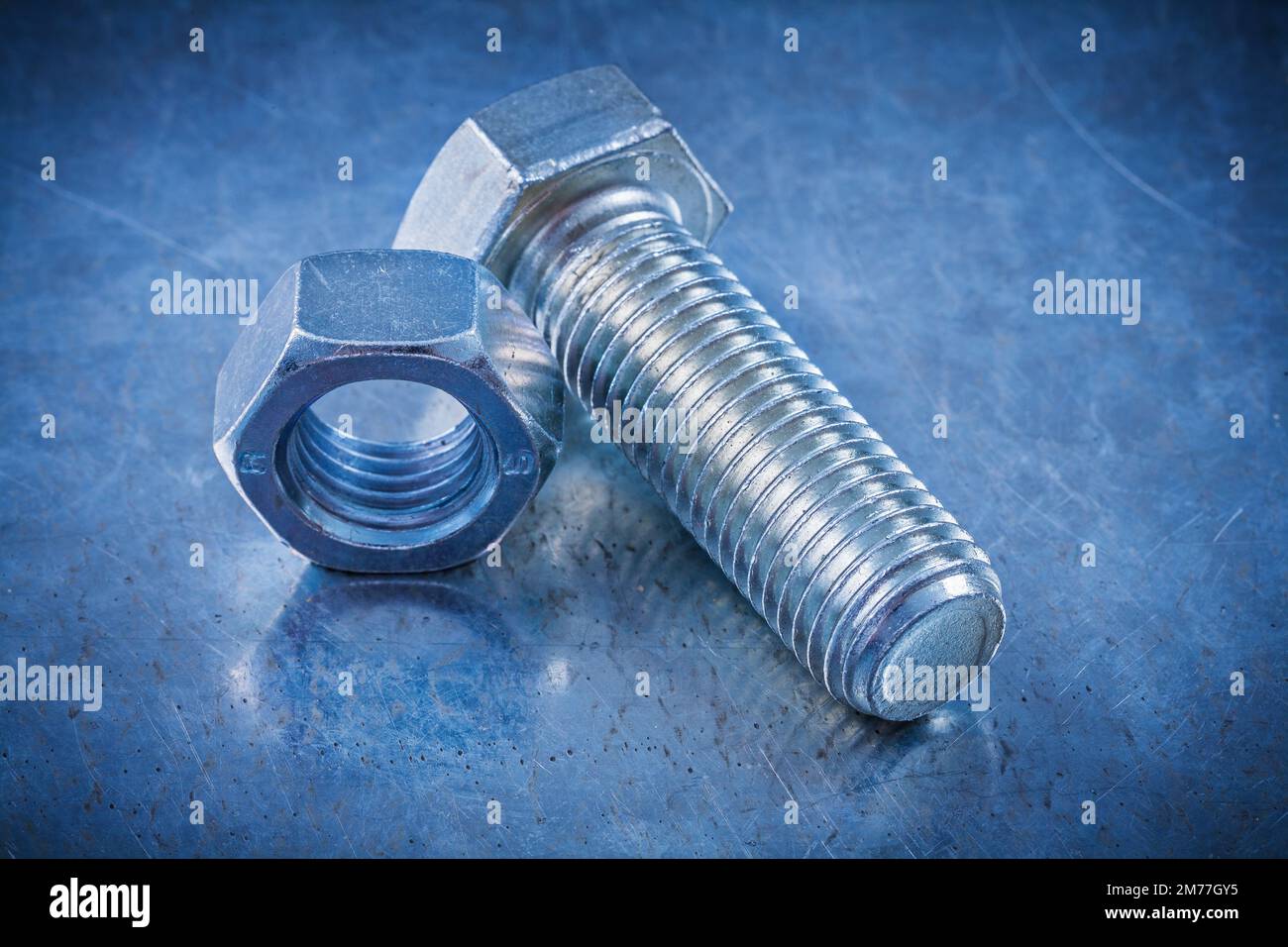 Threaded screwbolt and construction nut on metallic surface horizontal ...