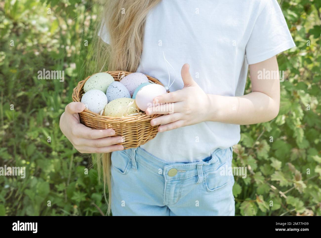 Cute little child wearing bunny ears on Easter day. Girl holding basket ...