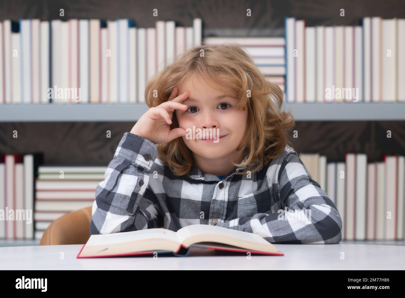Kid reading book in a book store or library Stock Photo - Alamy