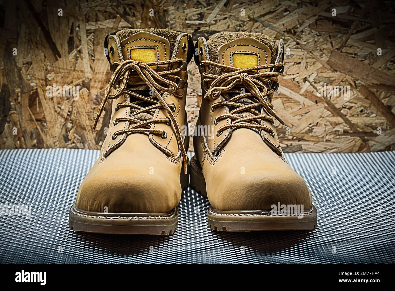 two brown working boots on plywood background Stock Photo - Alamy