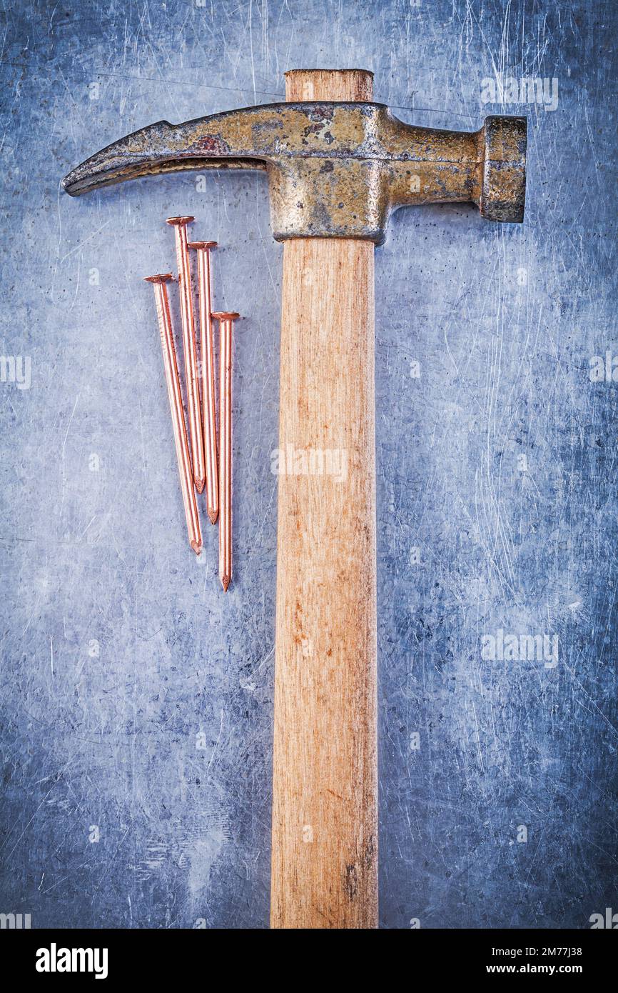 Vintage claw hammer copper construction nails on metallic background ...