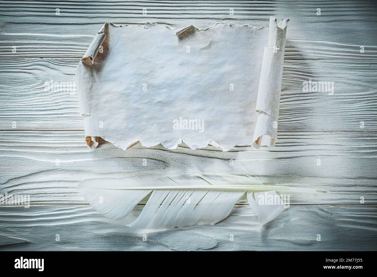 Vintage crumpled paper roll feather on wooden board Stock Photo - Alamy