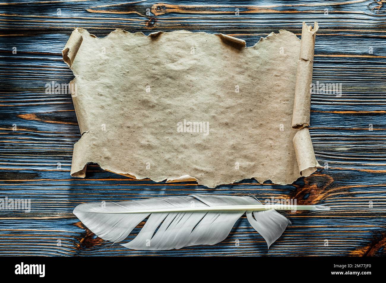Vintage paper roll plume on blue wooden board Stock Photo - Alamy