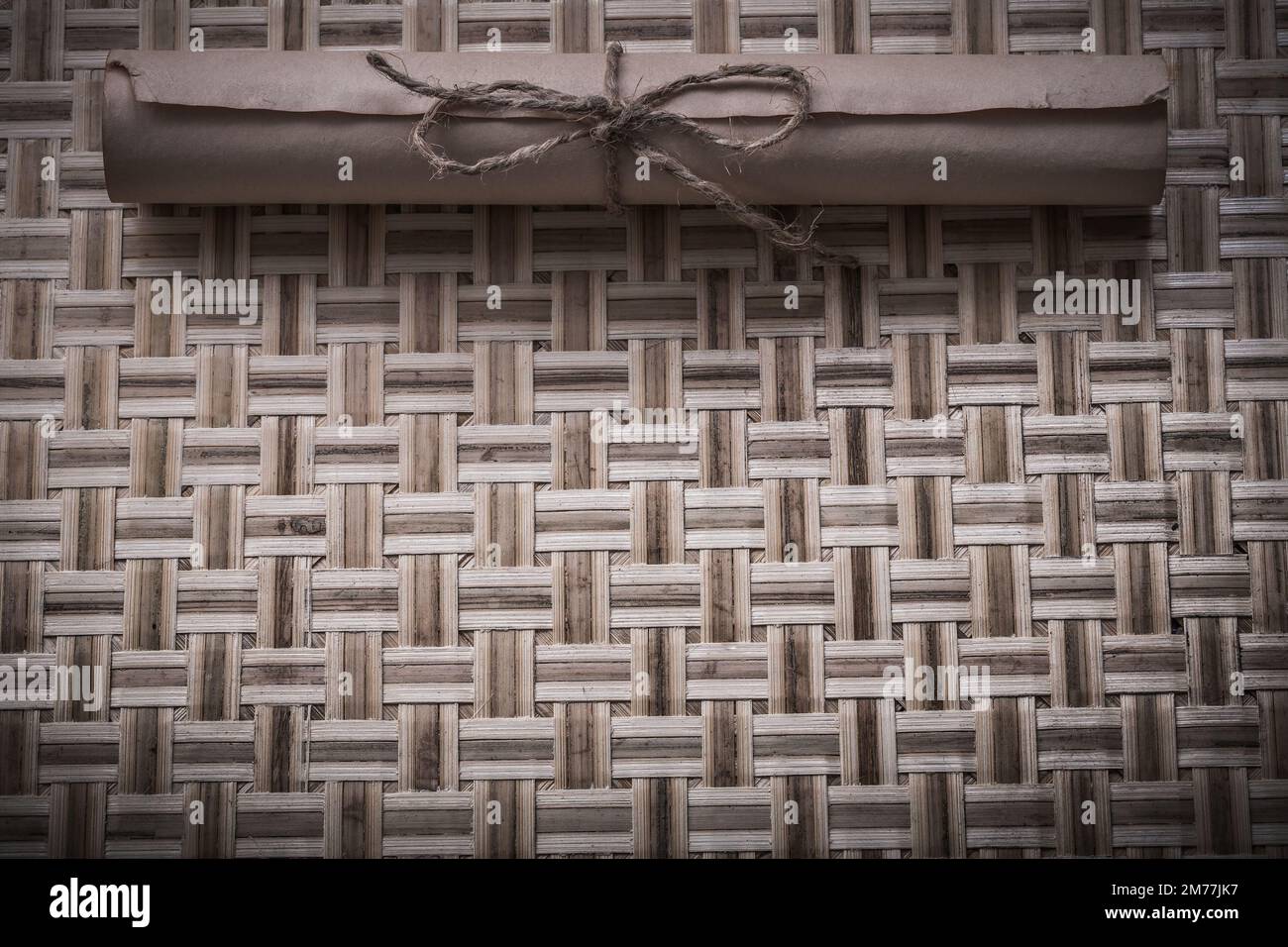 Vintage rolled document with string on wicker wooden mat Stock Photo ...