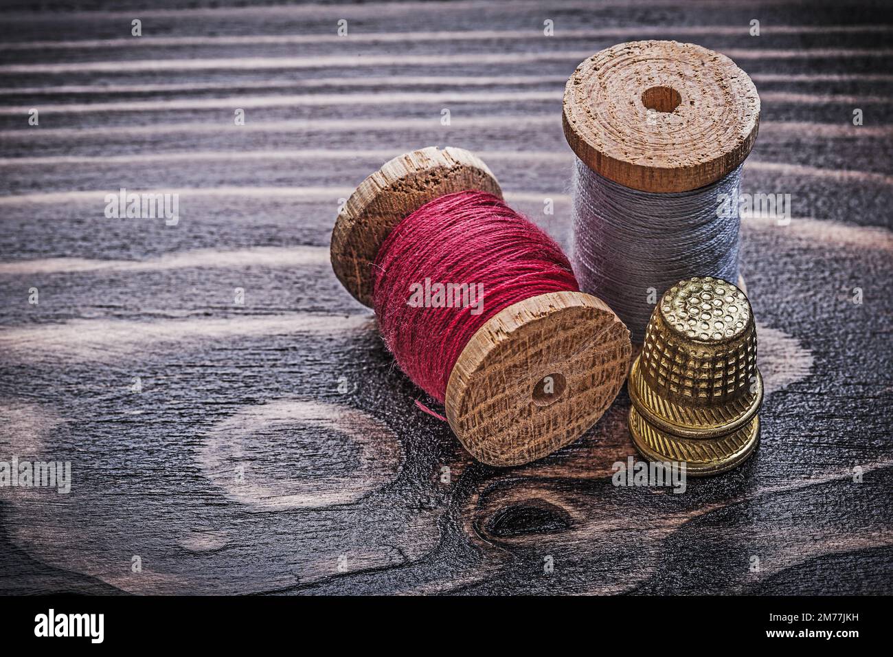 Vintage spools of thread thimbles on wooden board handicraft concept ...