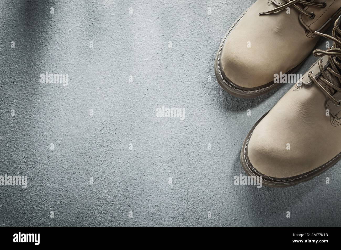 Waterproof safety boots on concrete background Stock Photo - Alamy