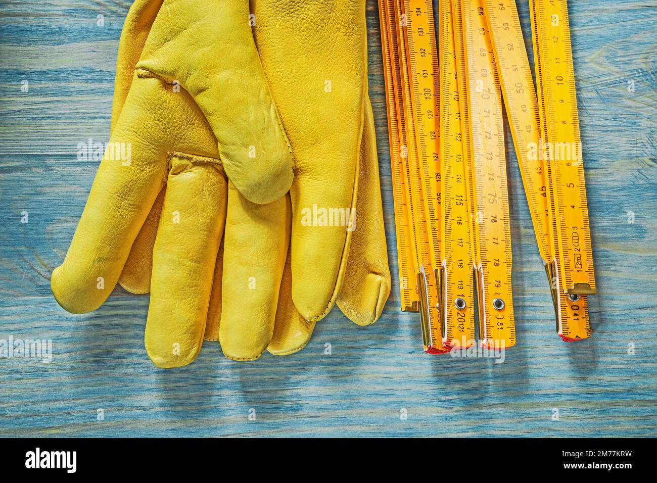 Wooden meter leather protective gloves on wood board construction ...