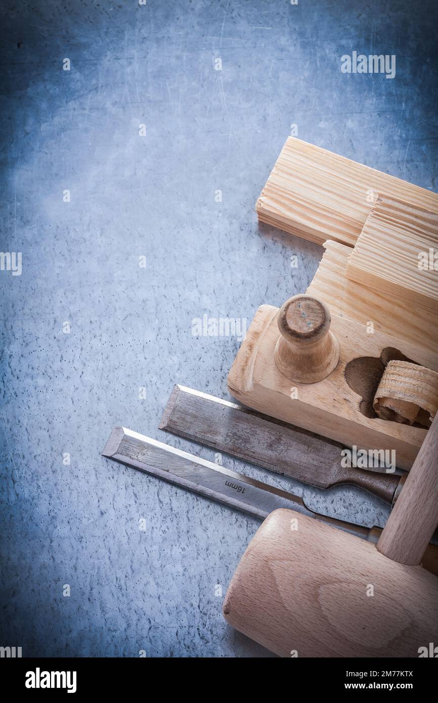 Wooden shaving plane hammer stud flat chisels on metallic background ...