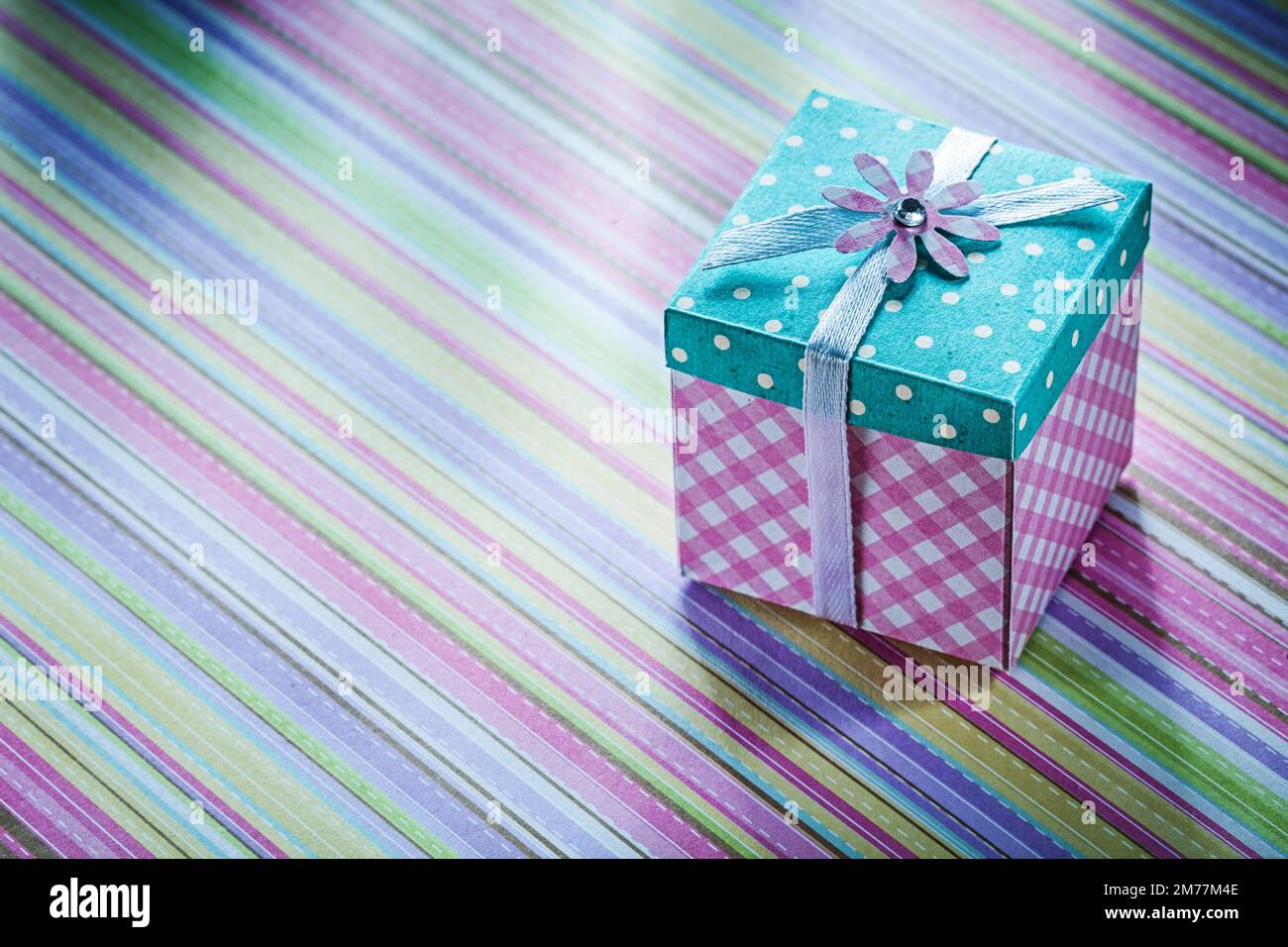Wrapped present box on stripy fabric background celebrations concept ...