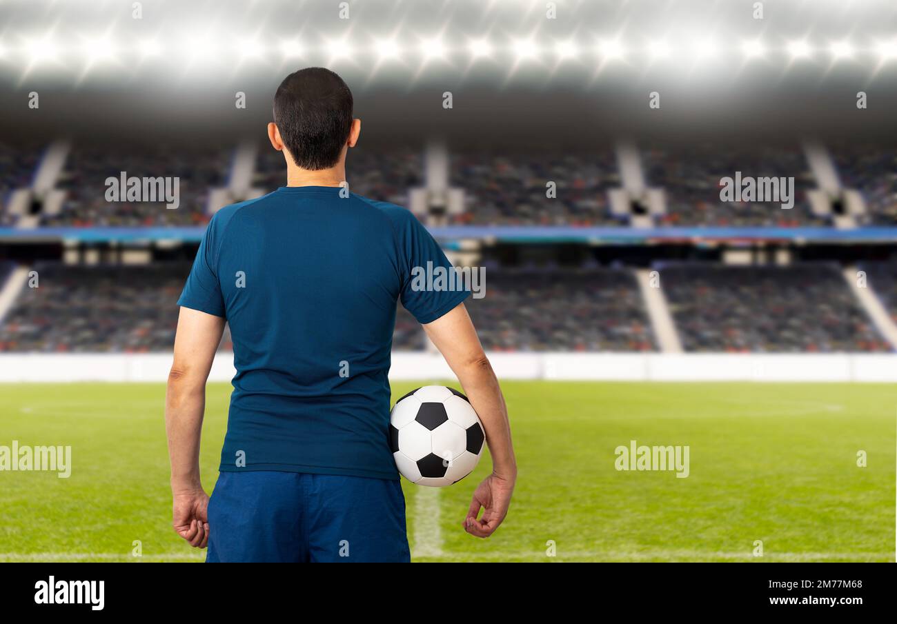 Cropped rear view image of a young player man holding a soccer ball ...