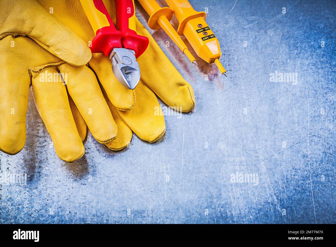 Yellow electrical tester safety gloves sharp cutting pliers on metallic ...