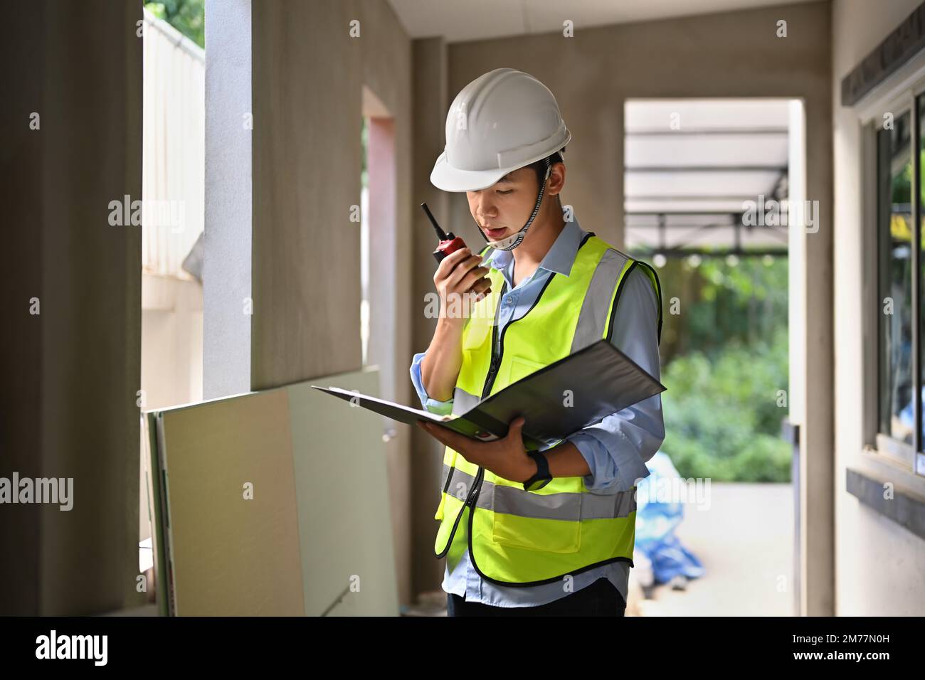 Civil engineer communicating with walkie talkie and working with ...