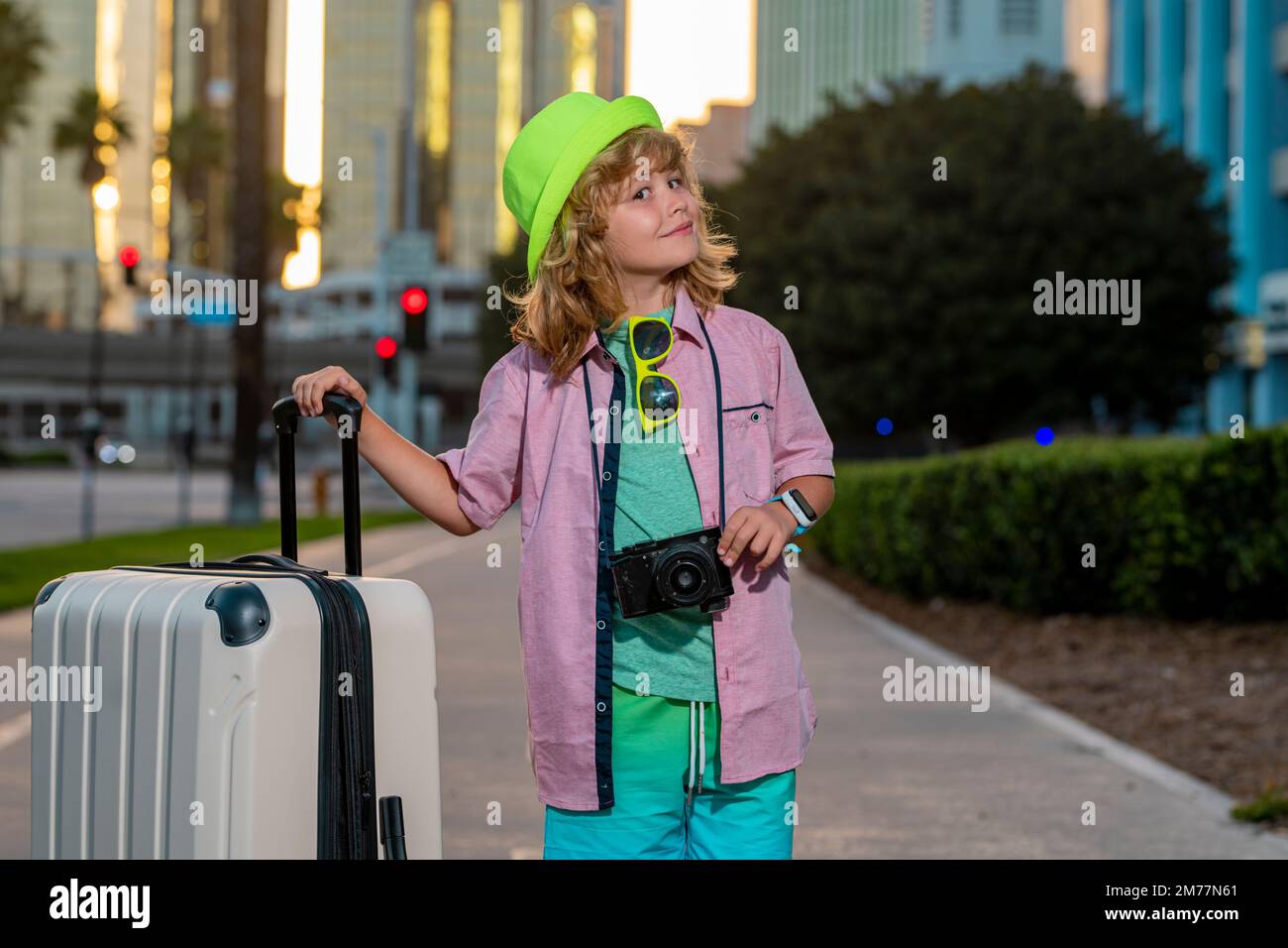 Kids travel. Happy child boy carrying travel suitcases outdoor on city ...