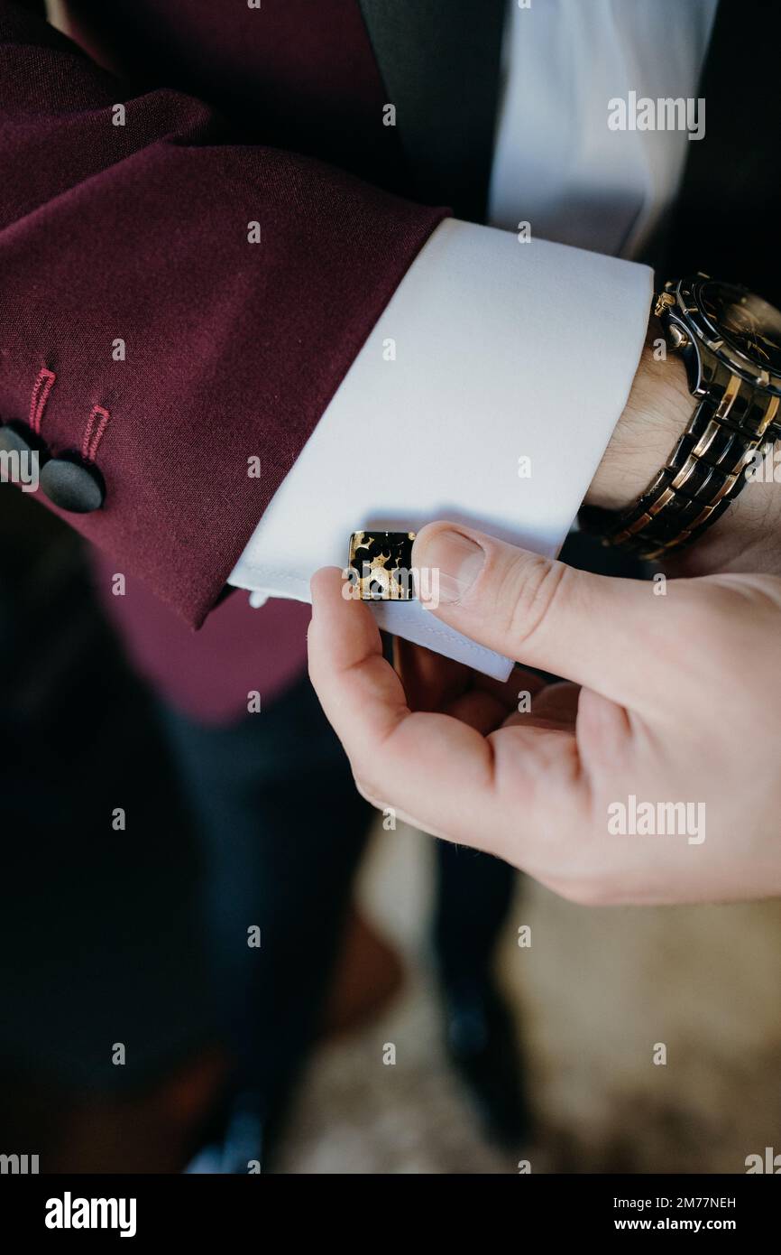 A groom fixing cufflinks on his shirt before the wedding ceremony Stock ...