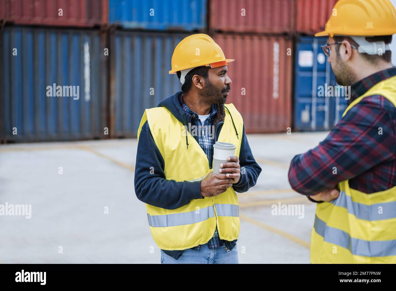 Workers controlling shipping containers at industrial port outdoor ...